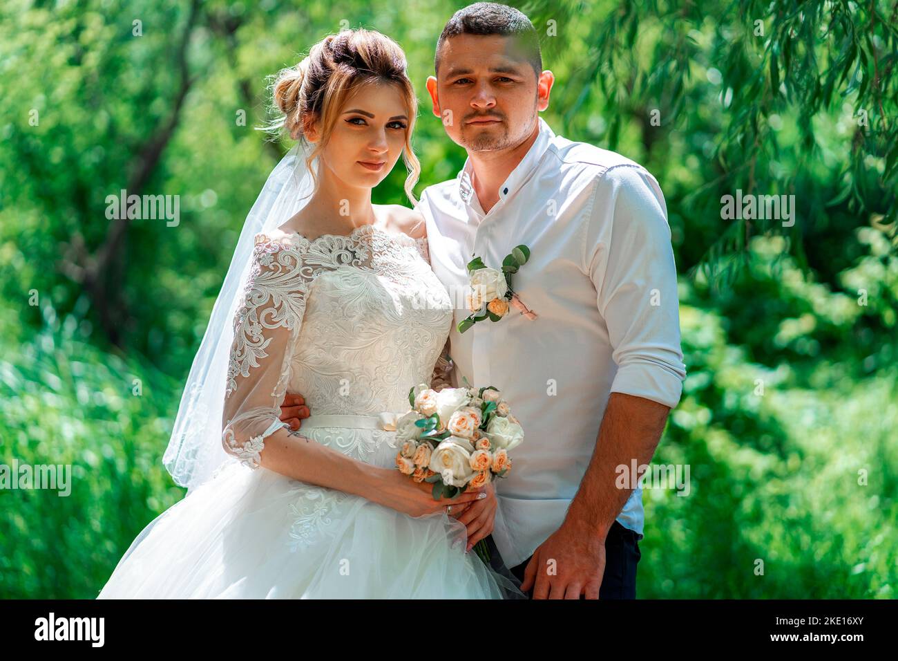 Bride hugging her husband and holding a bouquet of flowers Stock Photo ...