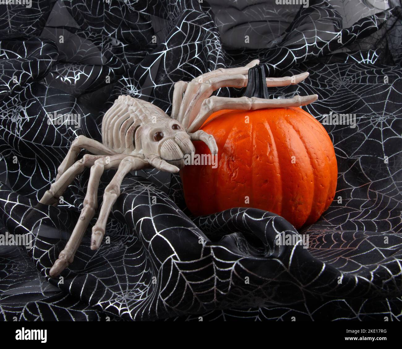 A scary spider skeleton, orange Halloween decor isolated on black ...