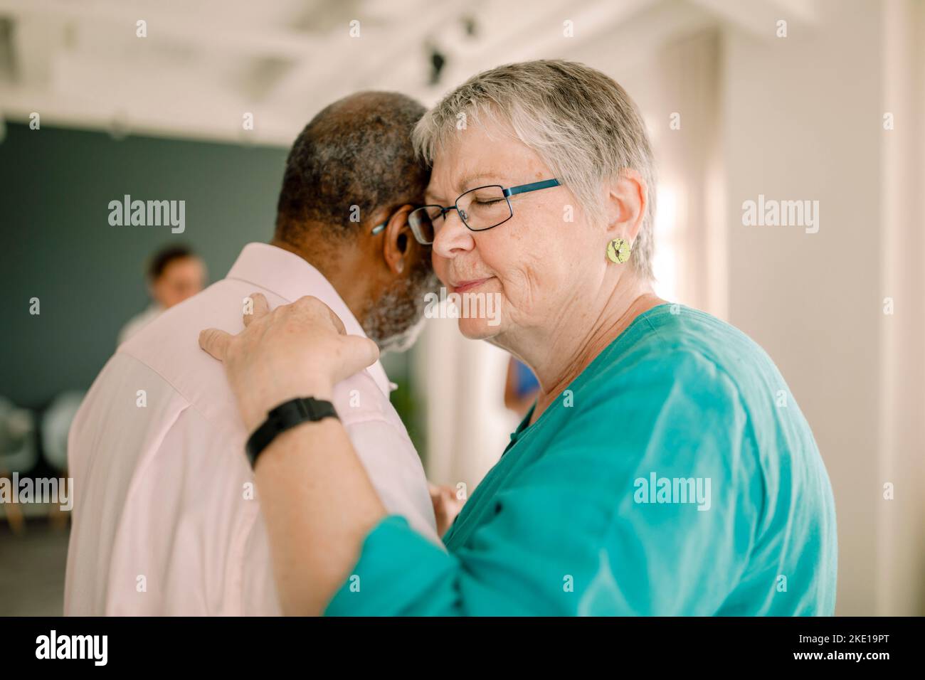 Senior woman with eyes closed dancing with man in class Stock Photo - Alamy