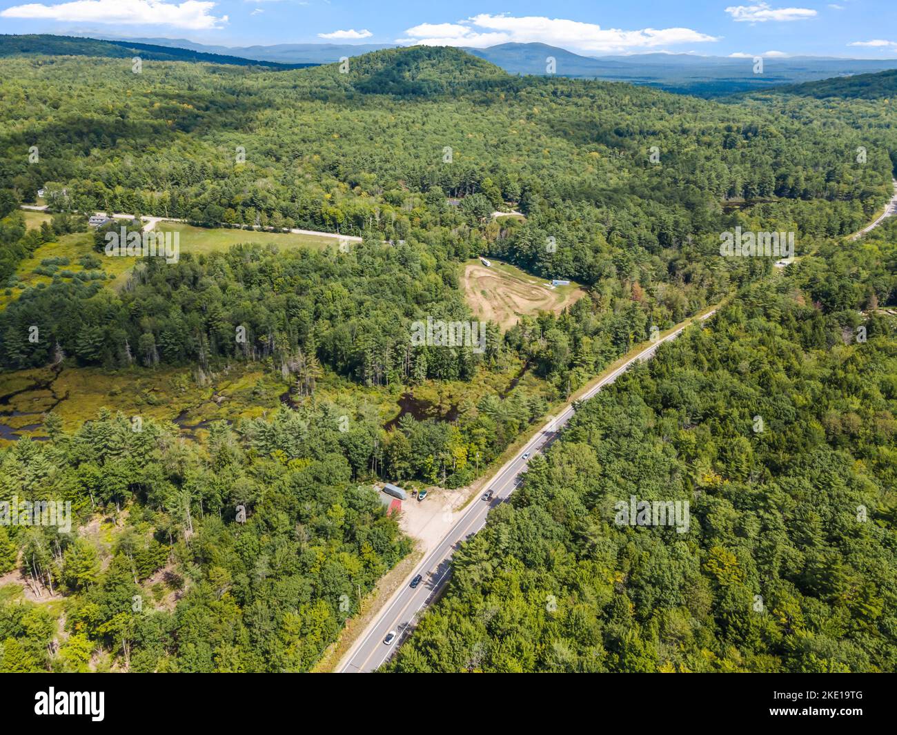 An aerial view of a forest with a modern custom new England colonial ...