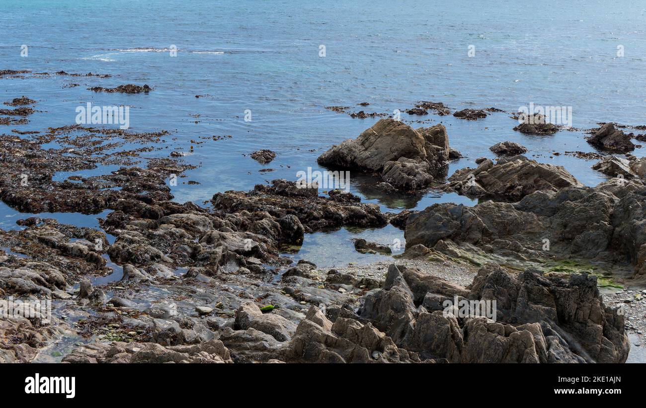 Rocky seashore, landscape. Calm water surface on a day Stock Photo - Alamy