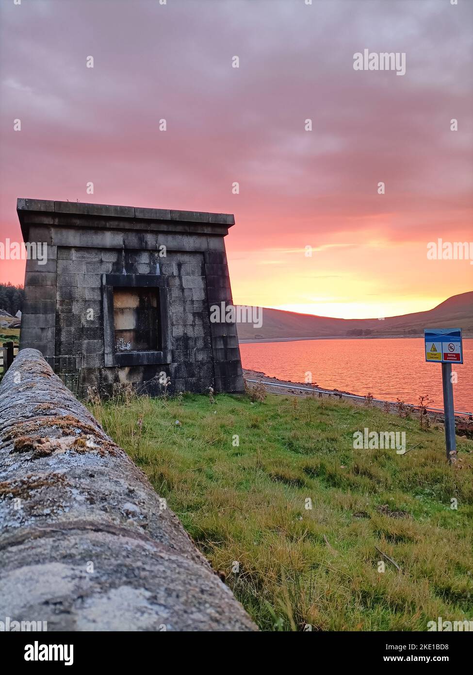 A vertical shot of an abandoned small stone building with a beautiful ...