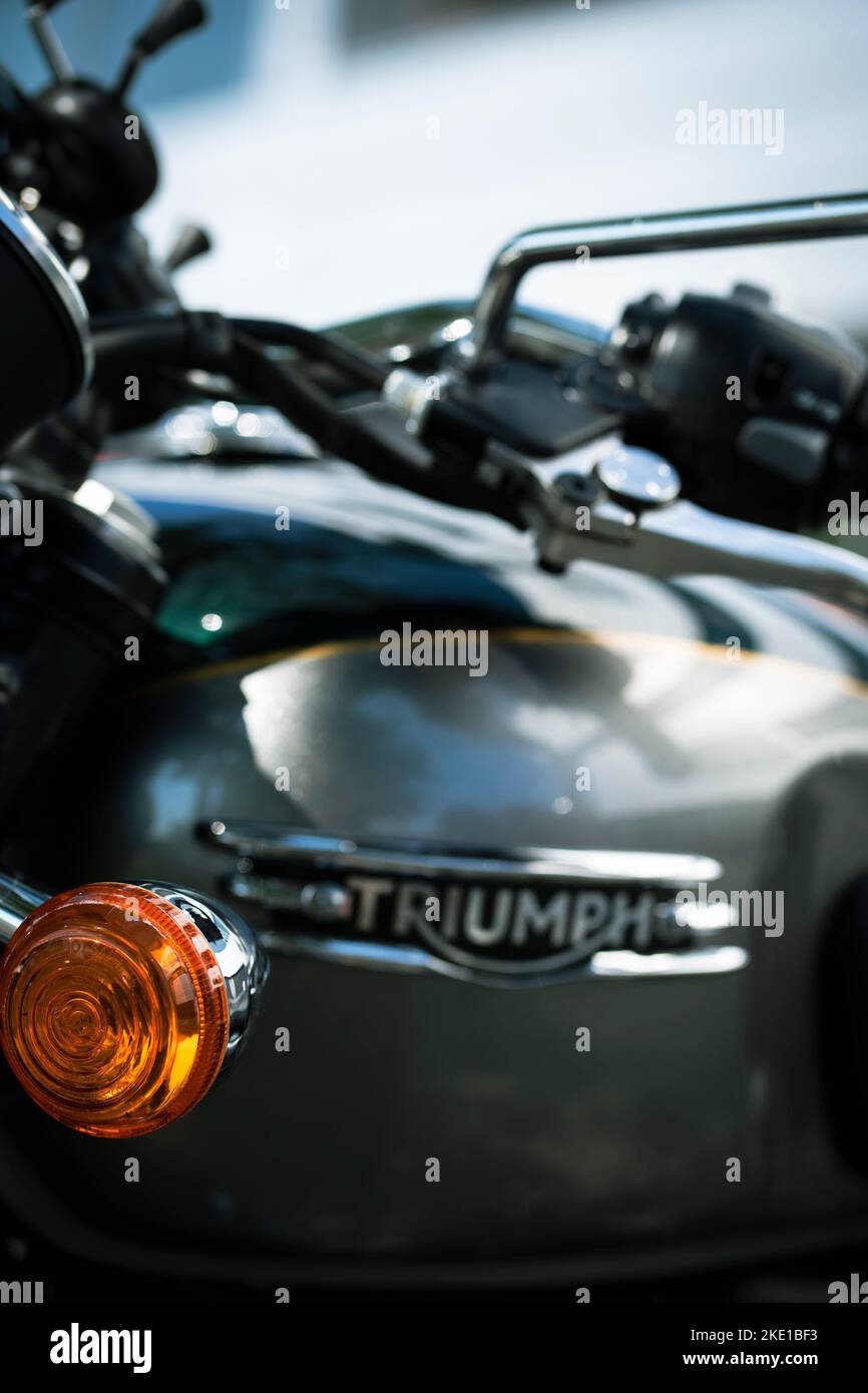 A vertical closeup of a gray motorcycle parked in the shades Stock ...
