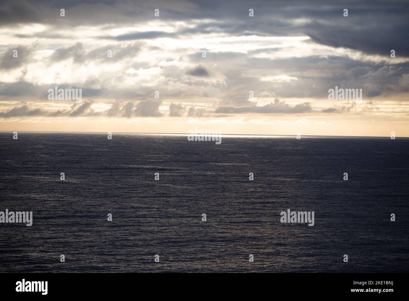 A view of the sea sunset with sun rays lightening the sky partly ...