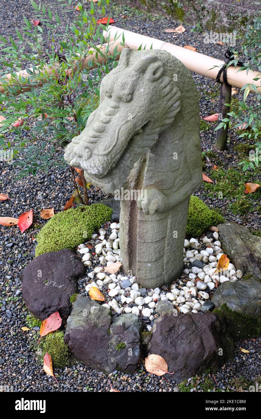 A concrete dragon statue in the garden of Saikyo-ji Buddhist temple in ...