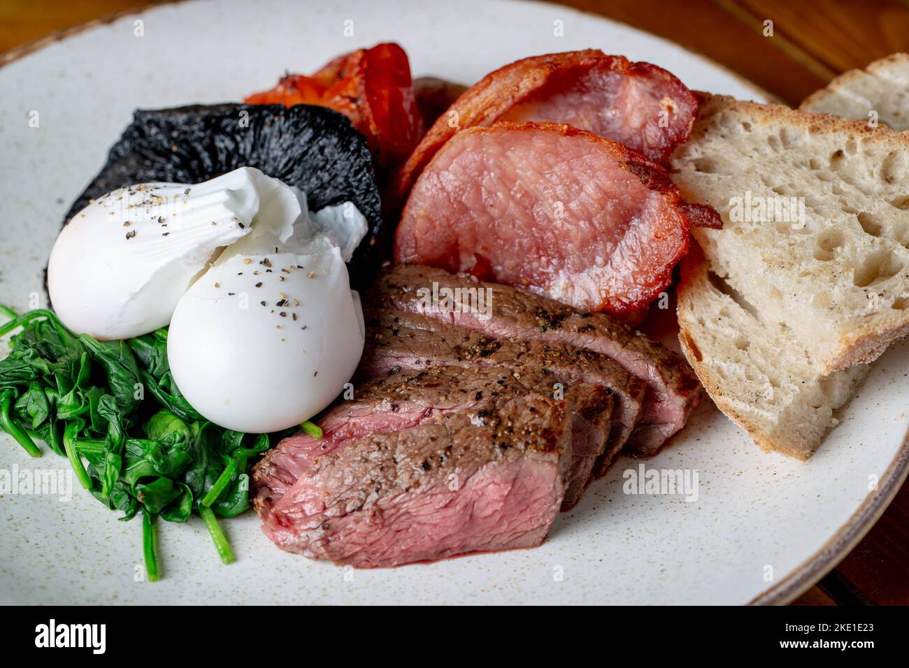 A healthy English breakfast of bread, steaks, eggs, bacon and greens ...