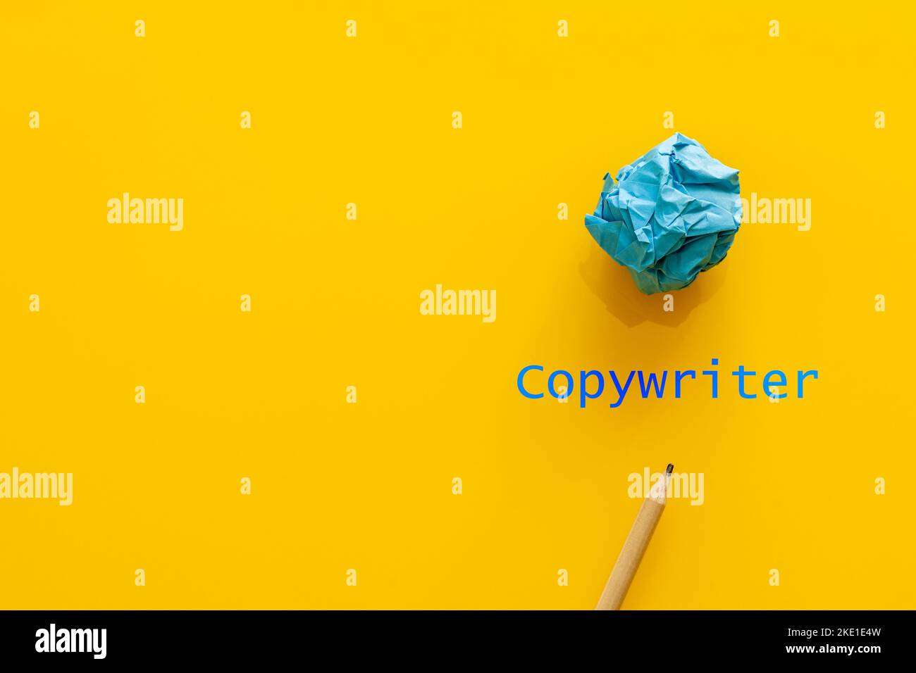 Blue text copywriter on a yellow background, next to a pencil and a ...