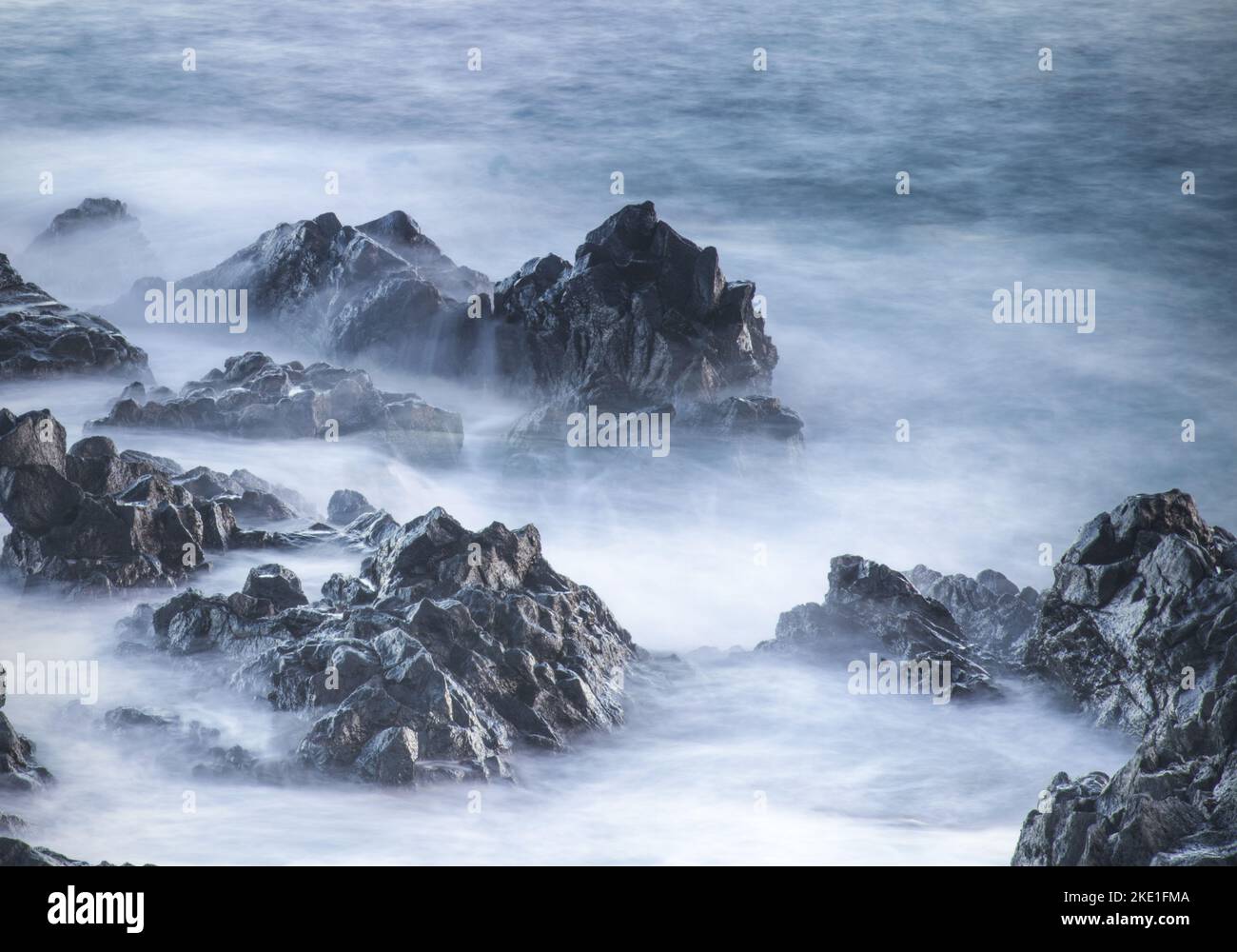Dark stones in ocean water, ideal for background Stock Photo - Alamy