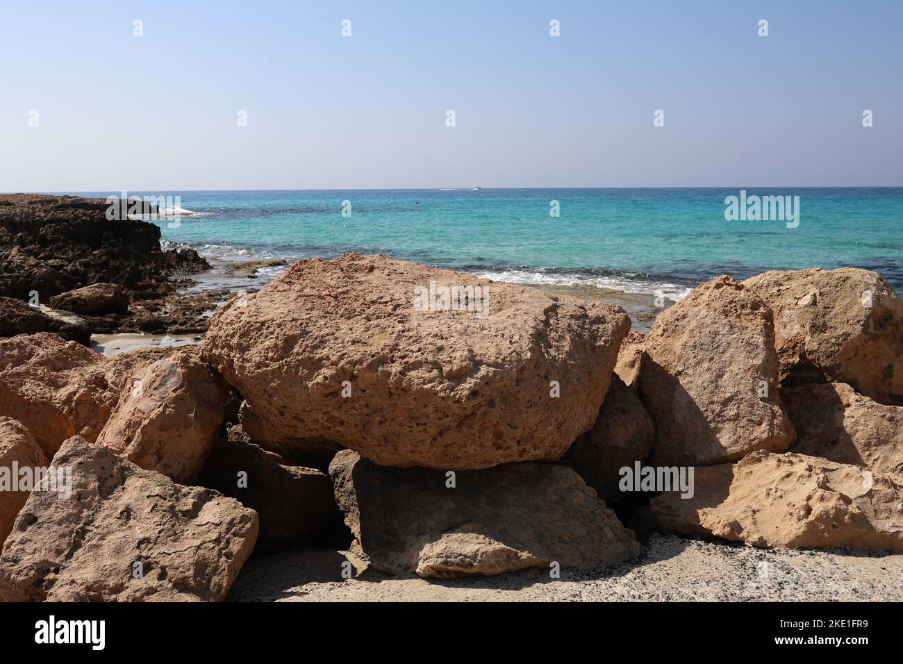 A rocky coast of the Mediterranean sea in Cyprus under the blue sky ...