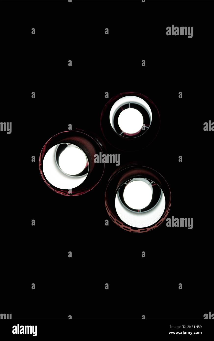 A vertical low-angle shot of three reflectors illuminating light on the ...