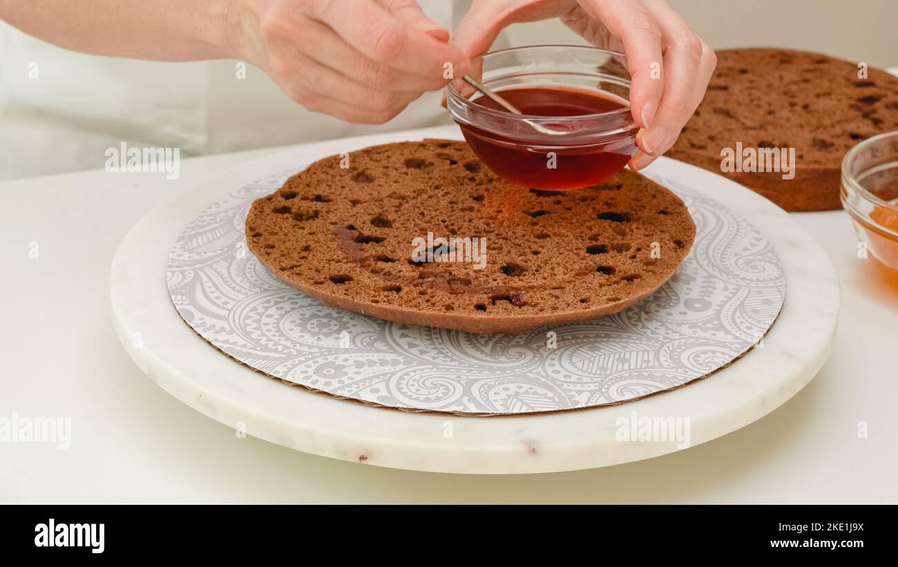 Woman hands pouring syrup over chocolate cake. Step by step chocolate ...