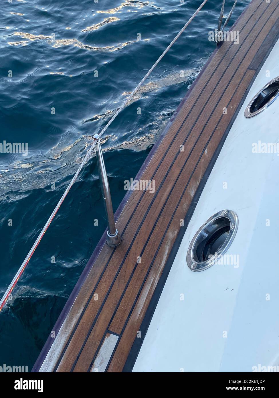 A vertical top view of a ship deck floating on beautiful blue ocean ...