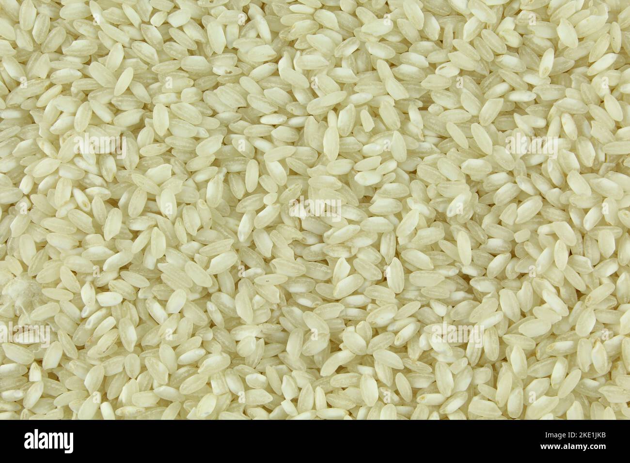 Raw uncooked white rice full background pattern Stock Photo - Alamy