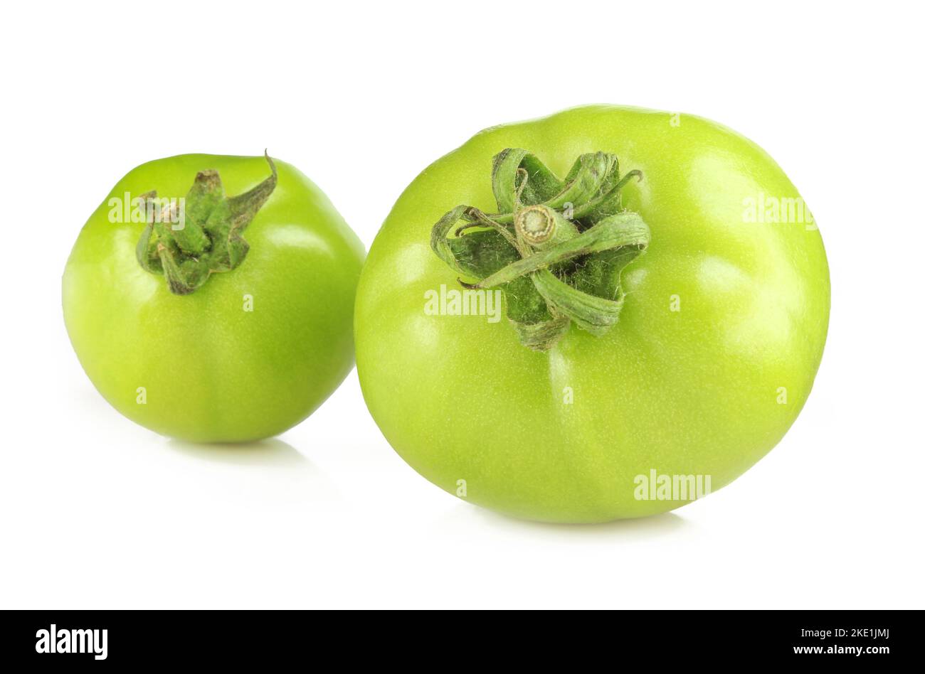 Two shiny green tomatoes isolated on white background Stock Photo - Alamy