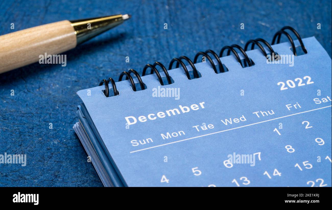 December 2022 - spiral desktop calendar against blue textured paper ...