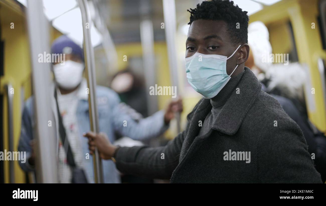 African man face close-up wearing covid-19 face mask inside public ...