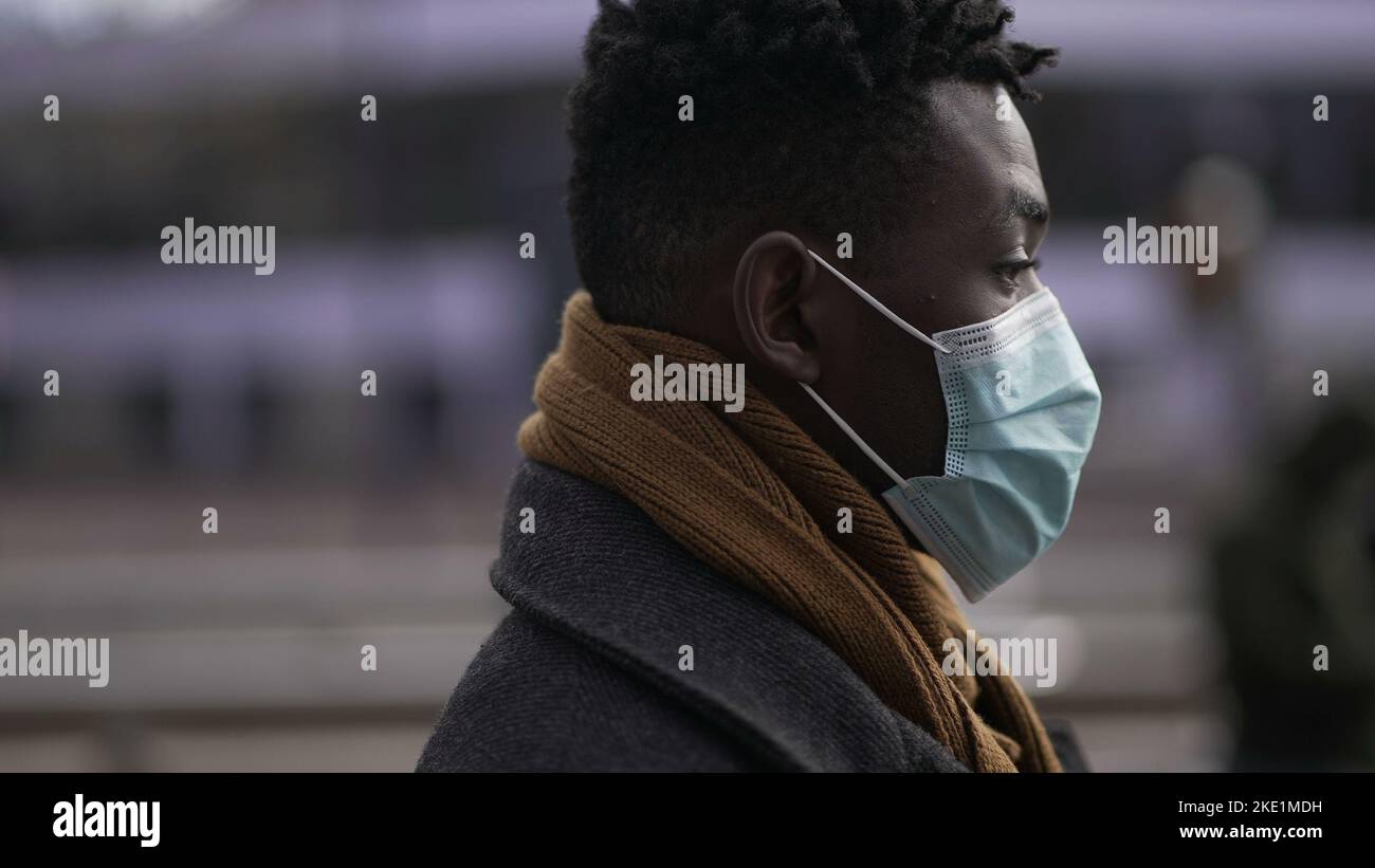 African man walking in city during pandemic times wearing covid mask ...