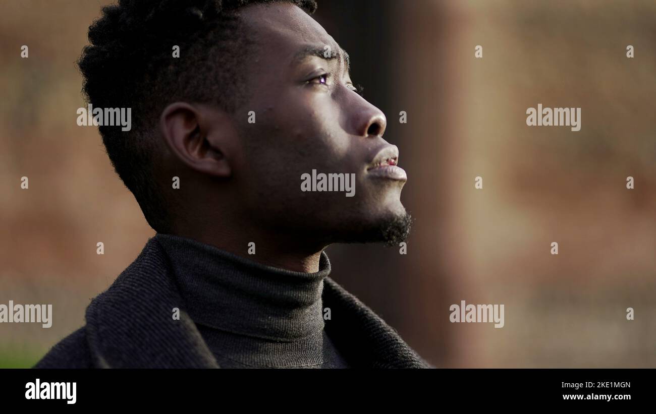African young black man standing at park looking up in contemplation2 ...