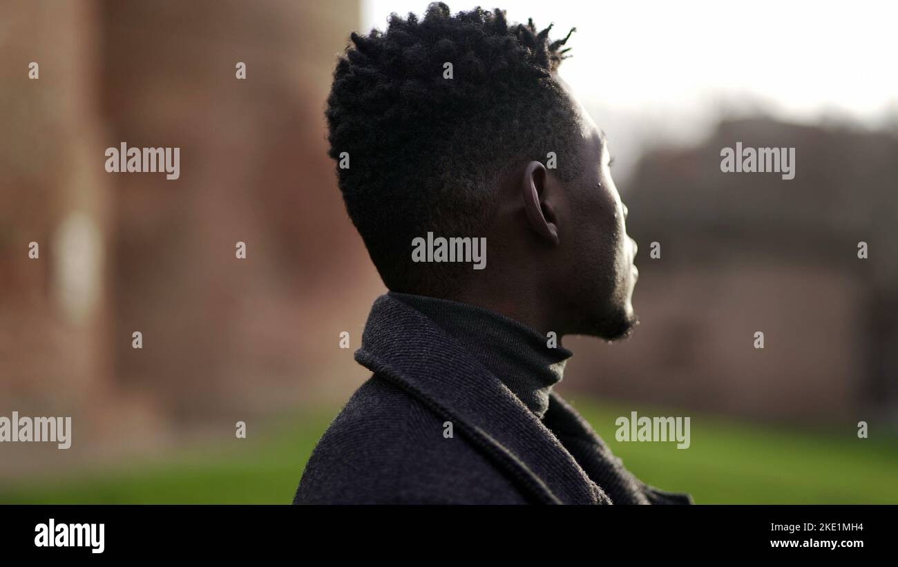 African young black man standing at park looking up in contemplation2 ...