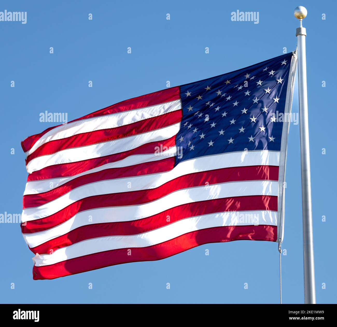 The American Flag waving on a pole Stock Photo - Alamy