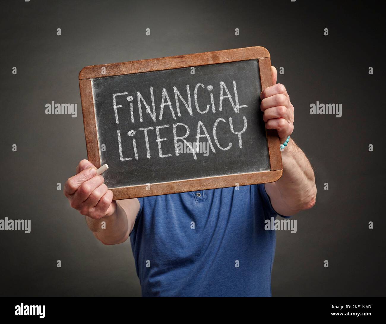 financial literacy white chalk on a blackboard held by a teacher ...