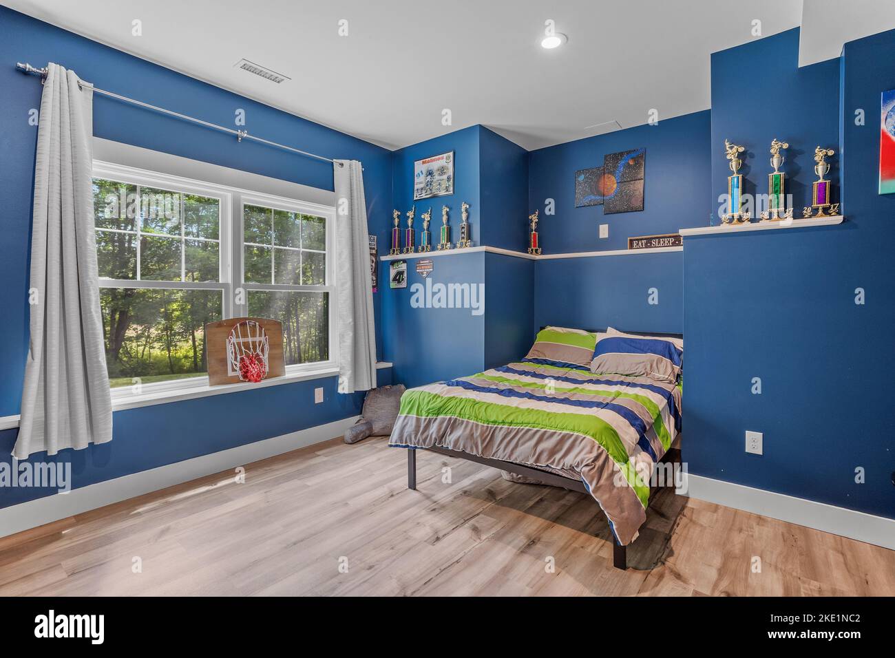The interior design of a bedroom with blue walls and trophies in a ...