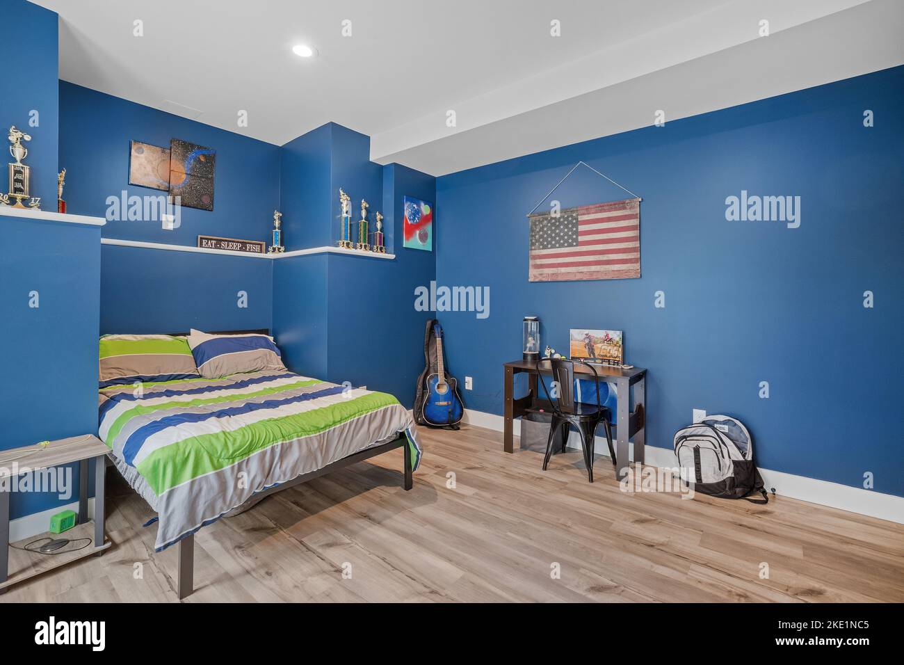The interior design of a bedroom with blue walls and trophies in a ...