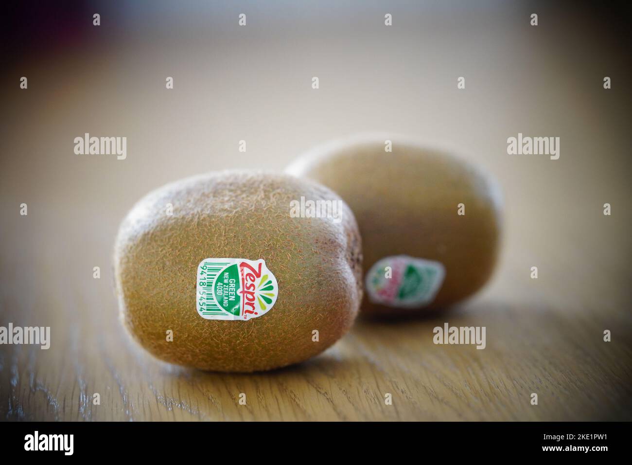 A Zespri brand sticker with logo on a kiwi fruit on a table Stock Photo ...
