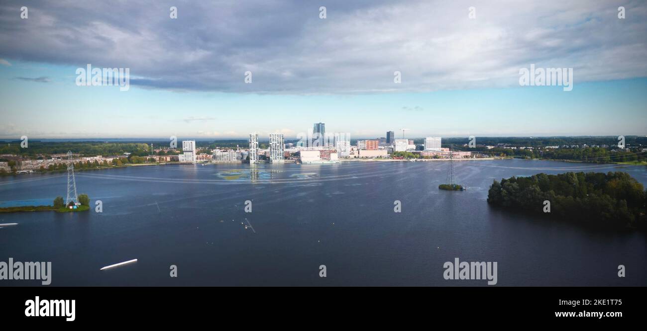 A scenic view of a city skyline and calm coast under a cloudy sky Stock ...