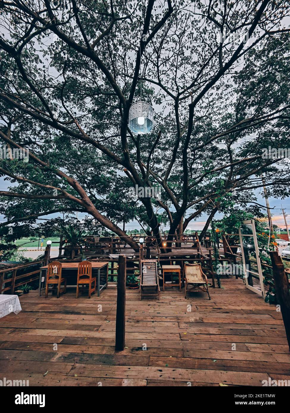 The vertical view of a fenced open-air place with wooden furniture and ...