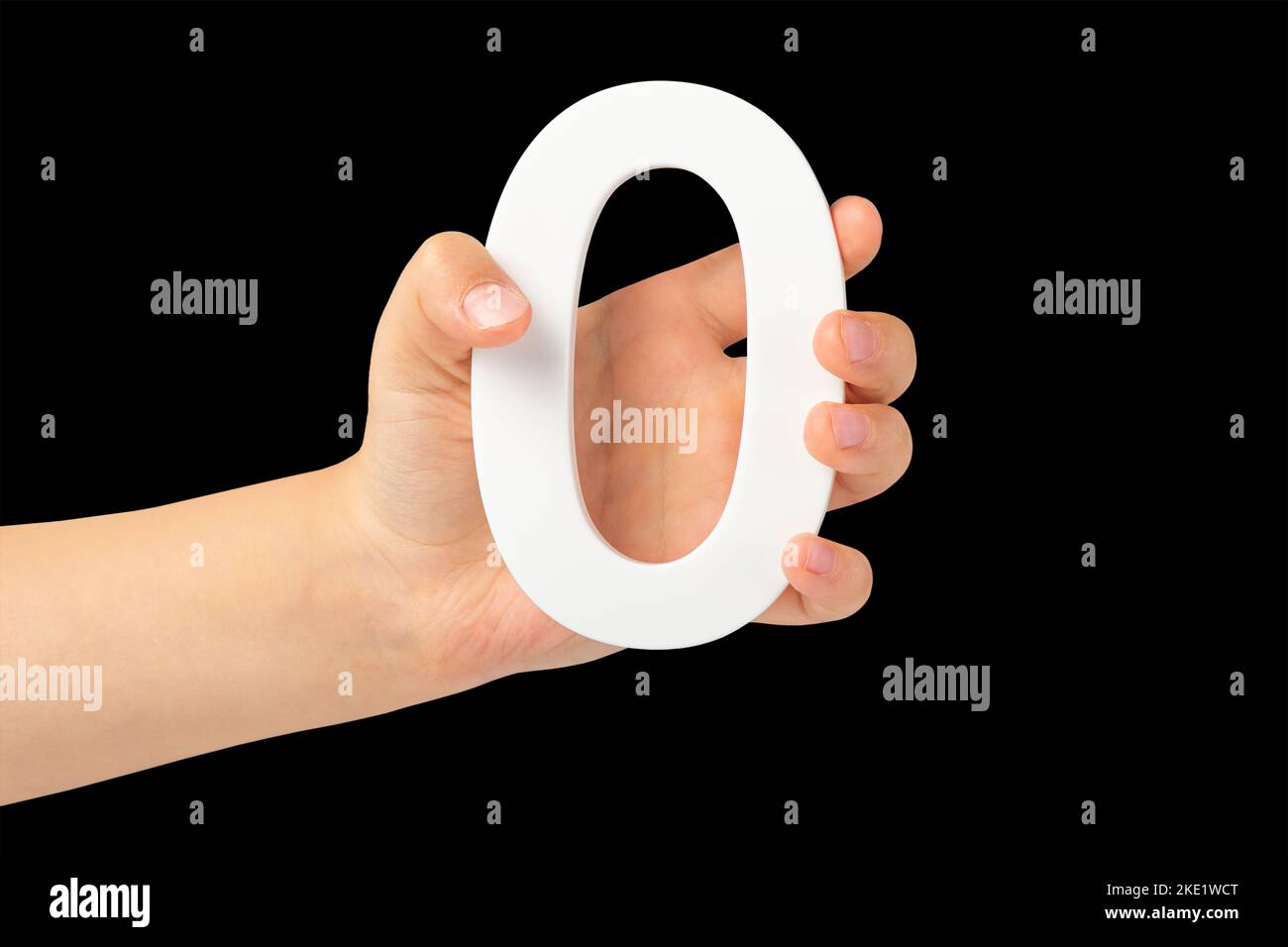 Zero in hand. The number zero is clasped in a hand isolated on a black ...