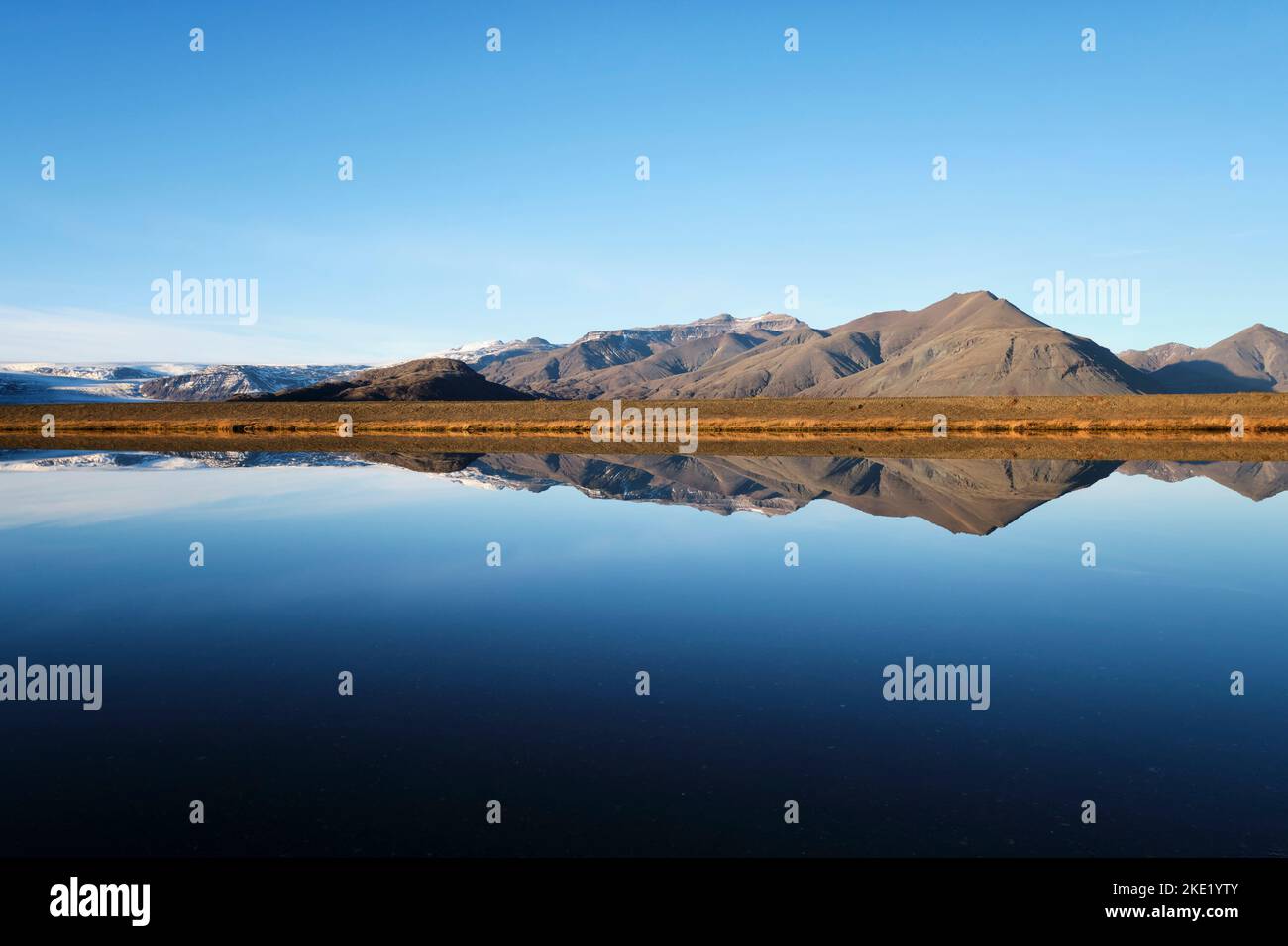 A lake reflecting the mountains and the clear blue sky, perfect for ...