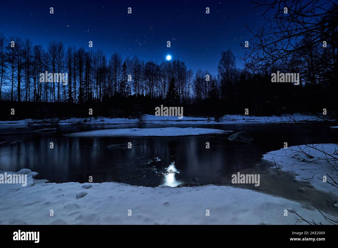 A small lake at night with a blue starry sky in the background, perfect ...