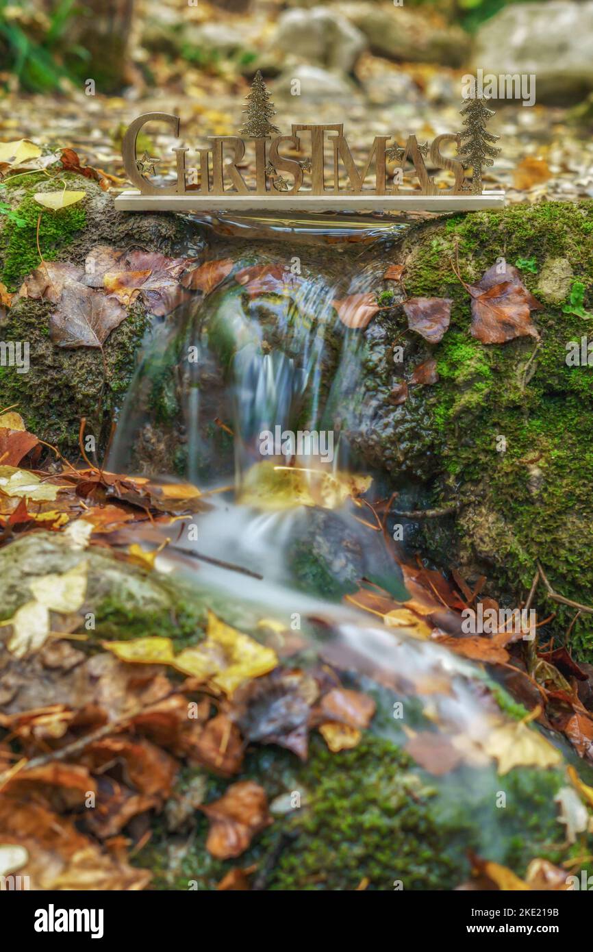 christmas sign on a waterfall of a river long exposure photography ...