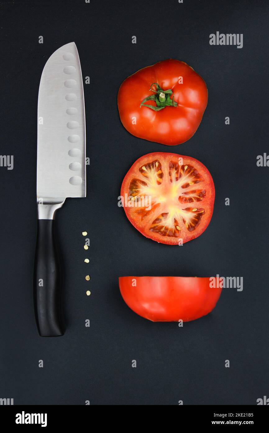 Fresh ripe tomato cutting on black background. Side view of the ...