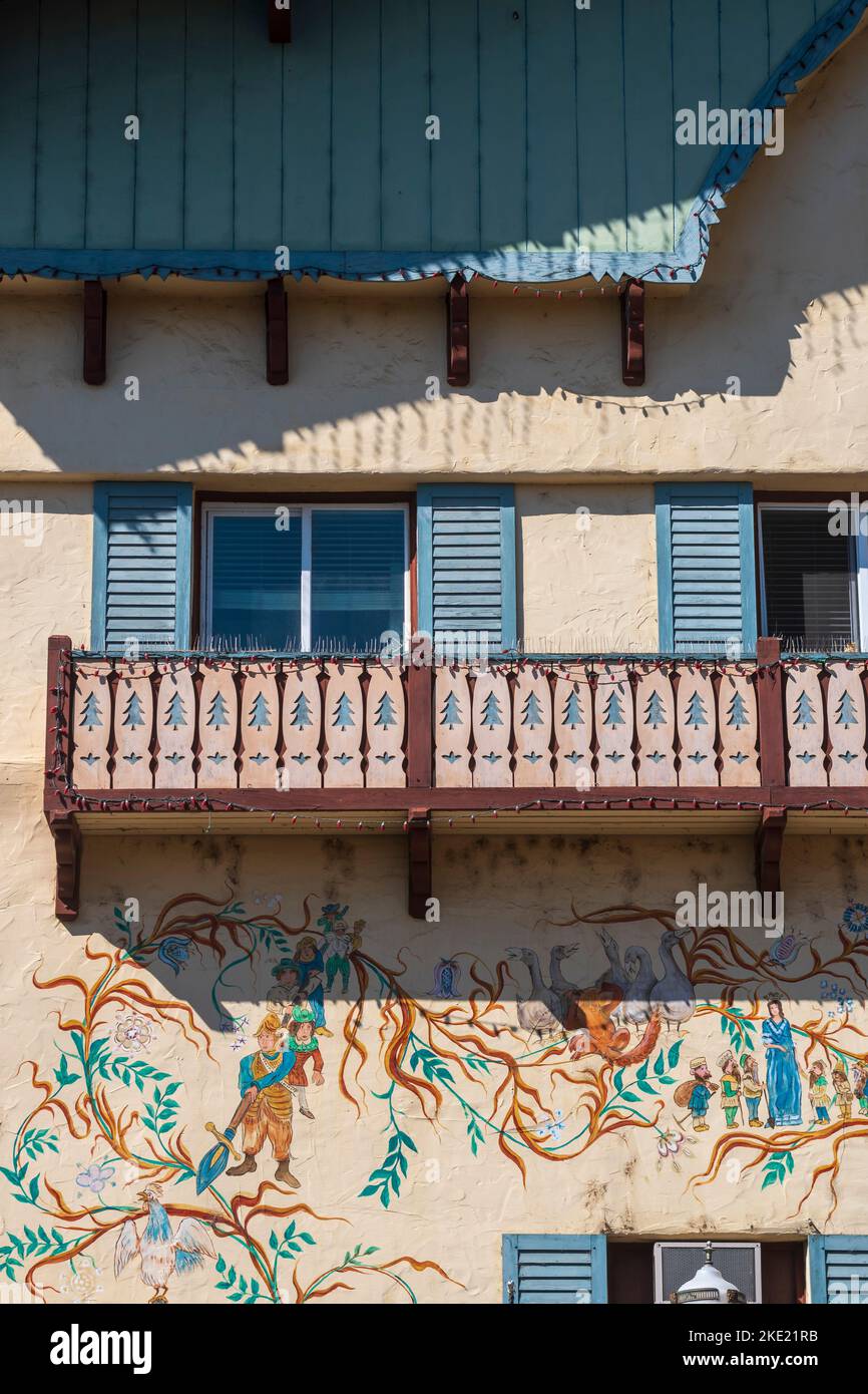 Fairy tale scenes painted on a building with blue shutters and a ...