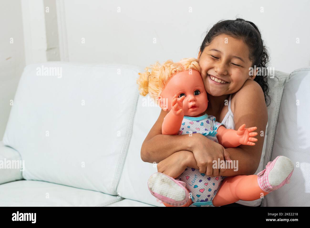 happy little brunette girl with the doll her parents just gave her ...