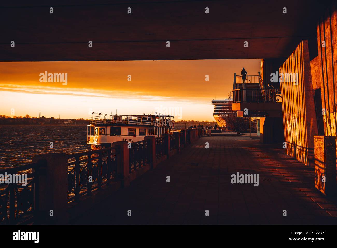 The view of the boat and empty quay at sunset. Riga, Latvia Stock Photo ...