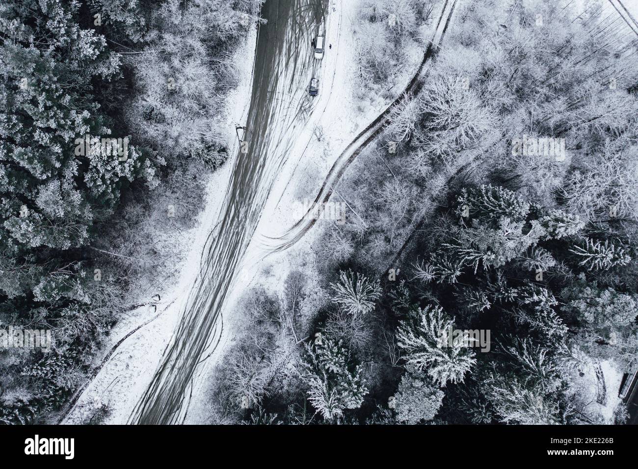 The view of a country road with car tracks surrounded by snow-covered ...