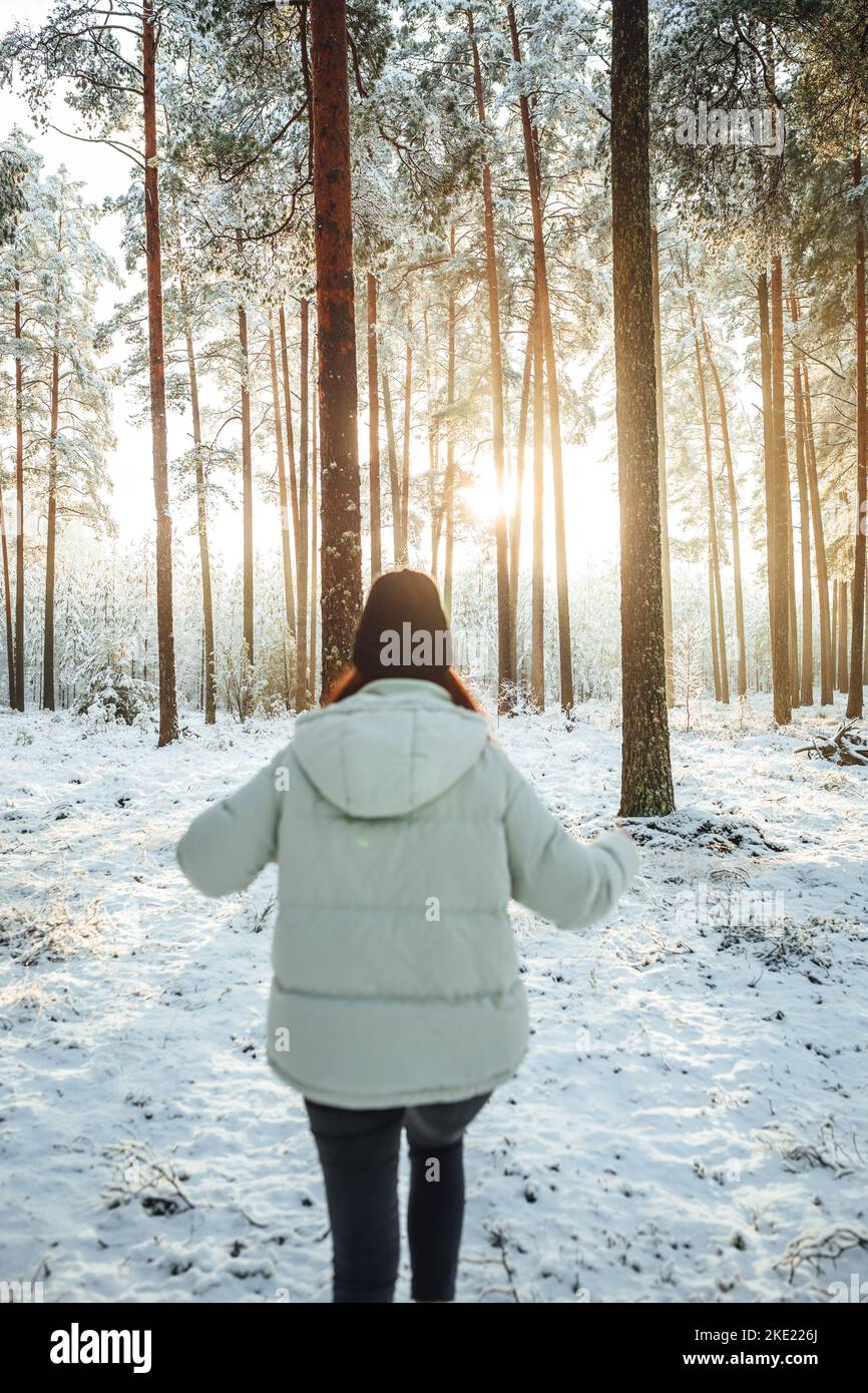 A vertical shot of the woman in a white puffer jacket against the ...