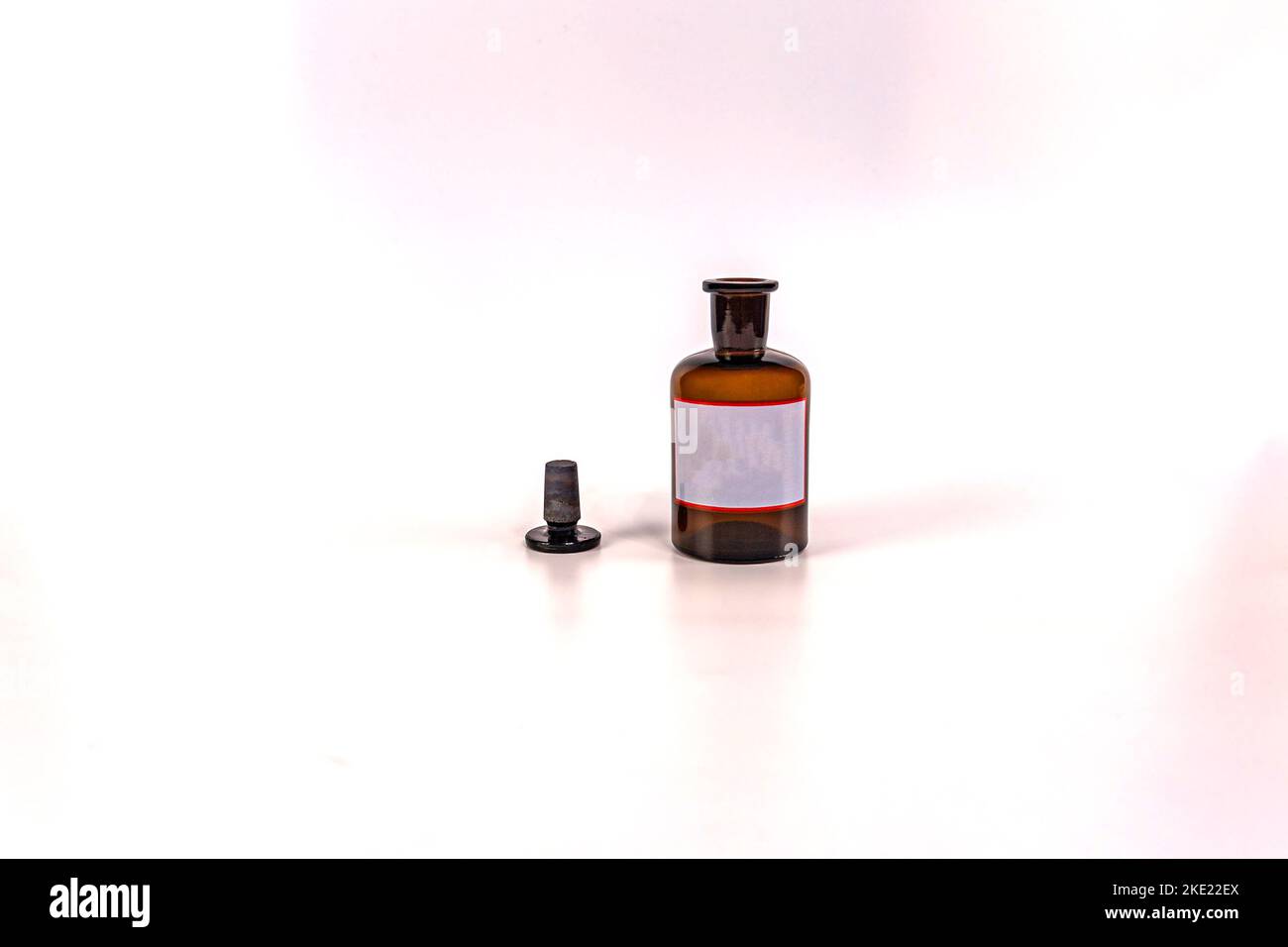 Brown medical jar with a glass stopper on a white background with a ...
