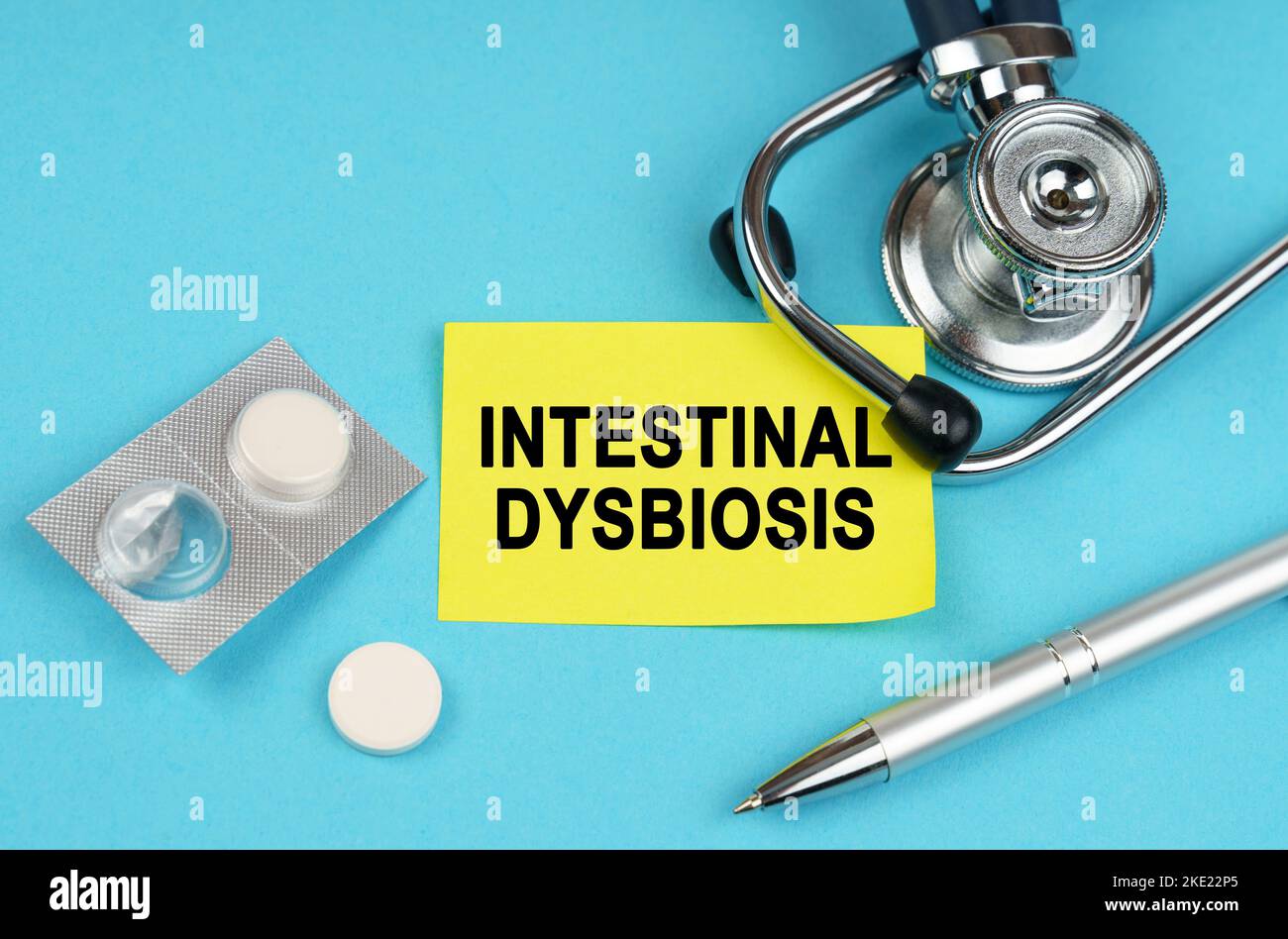 Medical concept. On a blue surface, a stethoscope, pills, a pen and a ...