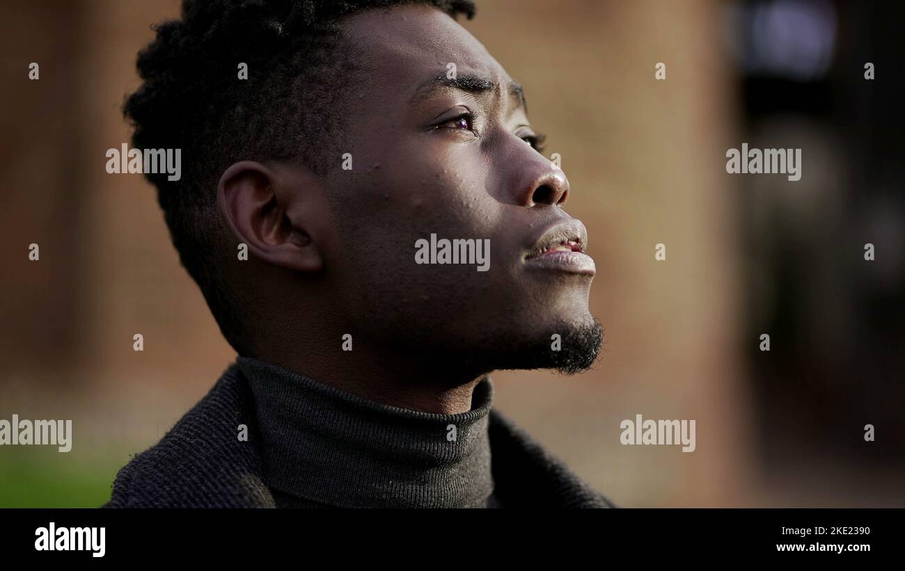 African young black man standing at park looking up in contemplation2 ...