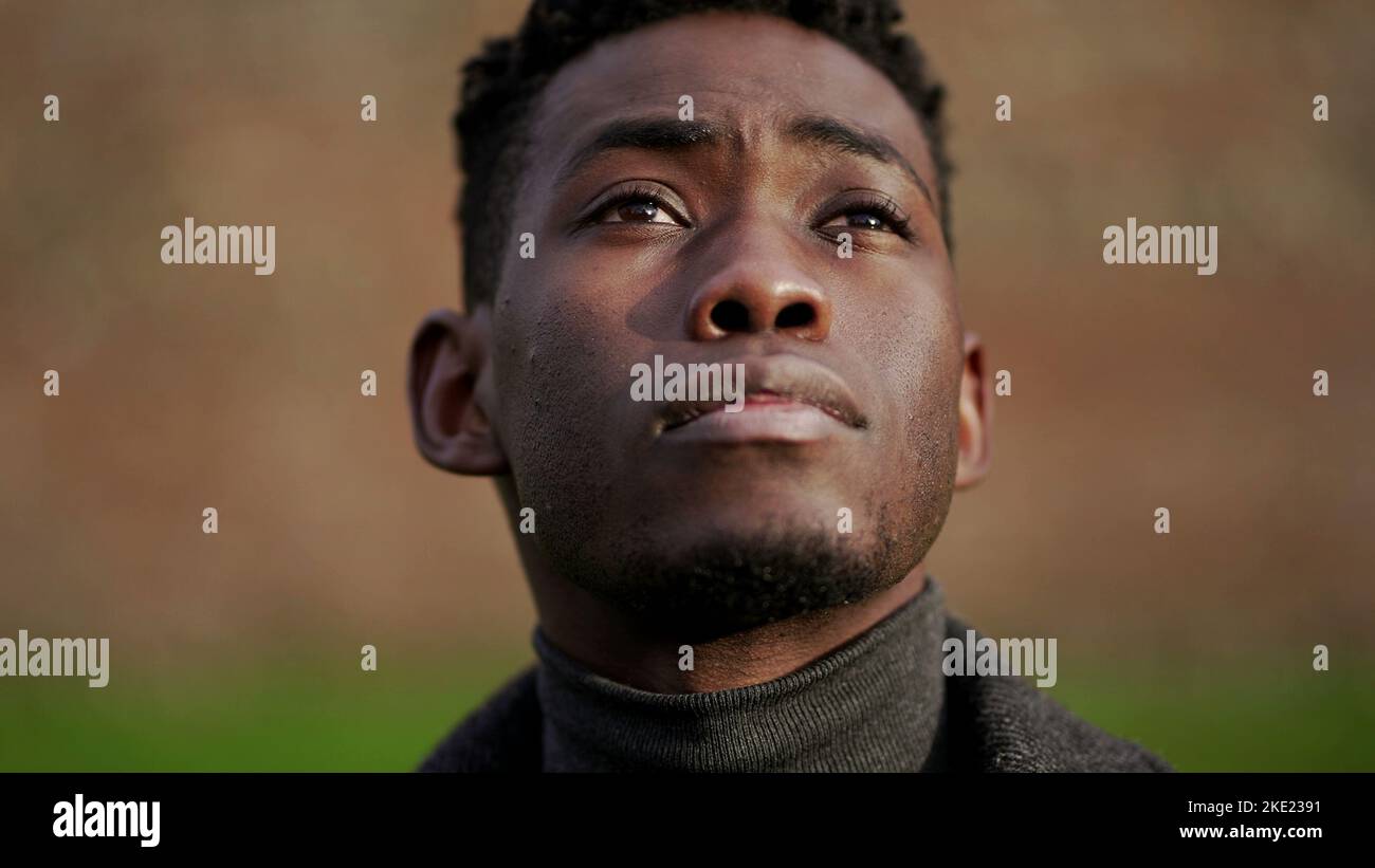 African young black man standing at park looking up in contemplation2 ...