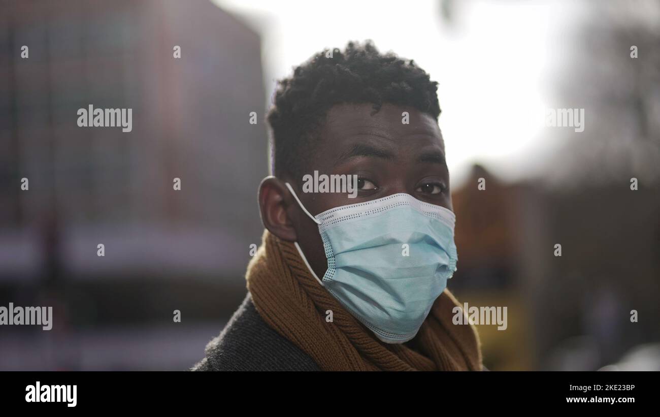 Black African man wearing covid-19 surgical face mask standing outside ...