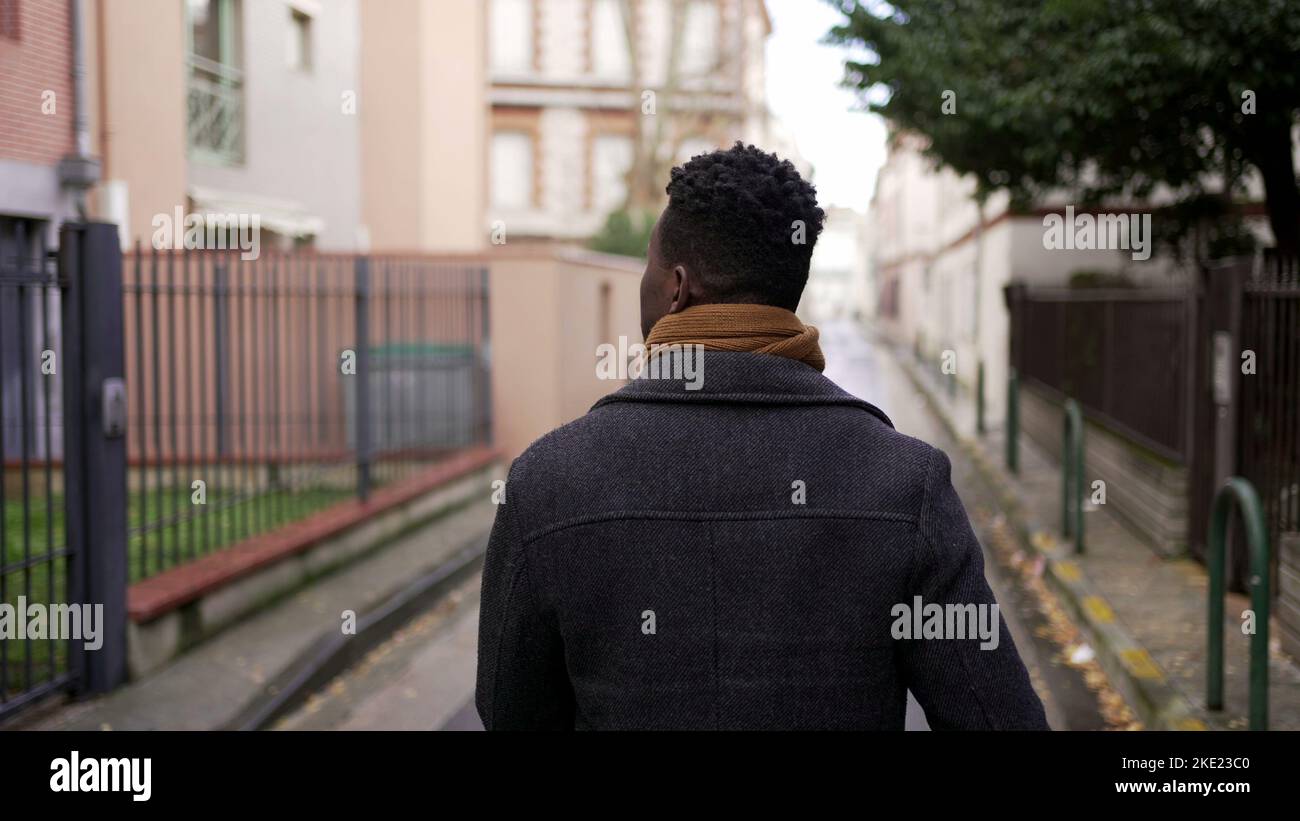 Back of black walking outside in city. African person perspective in ...
