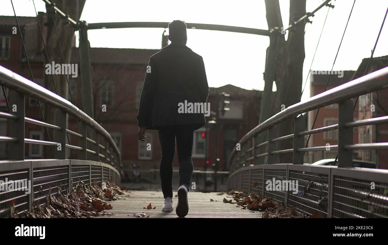 Back of person walking on top of bridge outside Stock Photo - Alamy