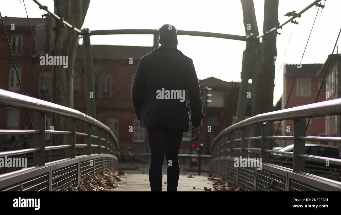 Back of person walking on top of bridge outside Stock Photo - Alamy