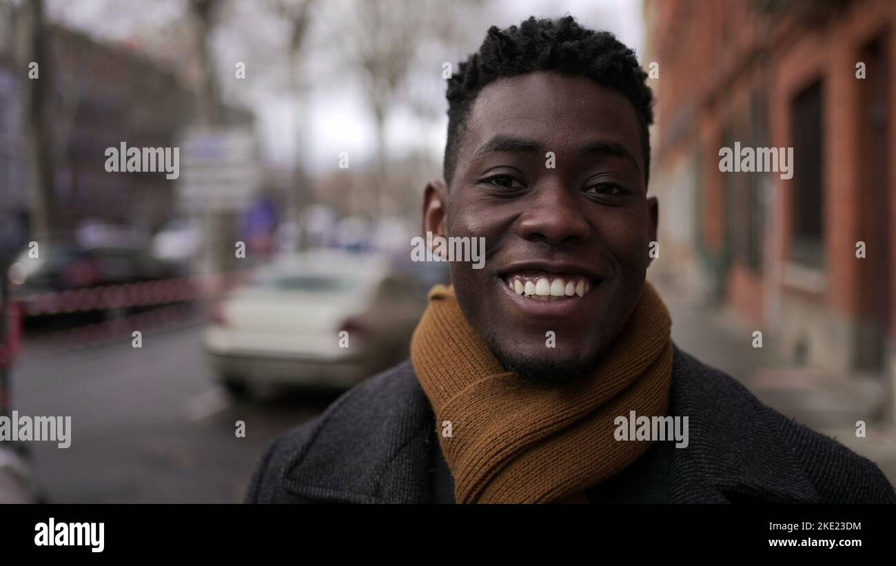 Black African man turning head towards camera and smiling in downtown ...