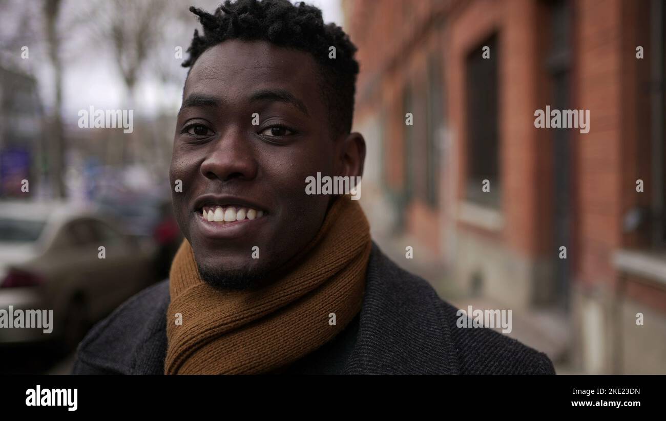 Black African man turning head towards camera and smiling in downtown ...